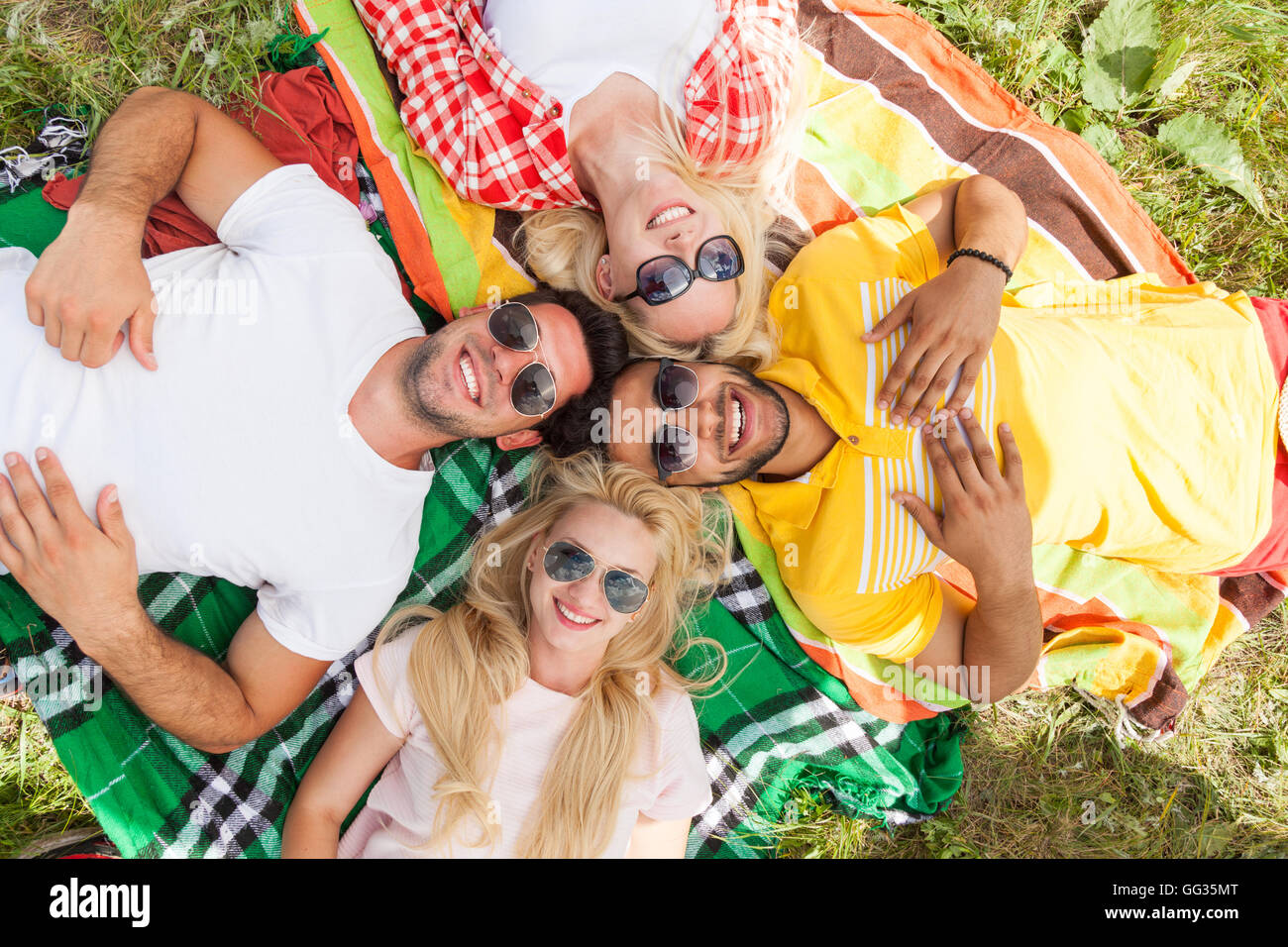 Happy people group young friends lying down on picnic blanket outdoor ...