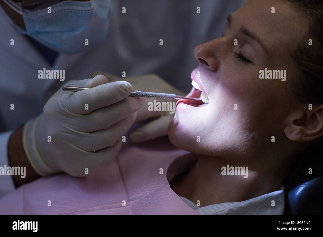 Dentist examining a patient with tools Stock Photo - Alamy