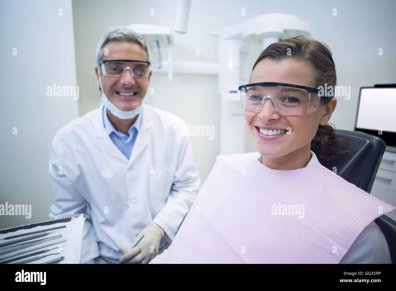 Dentist smiling with female patient Stock Photo - Alamy