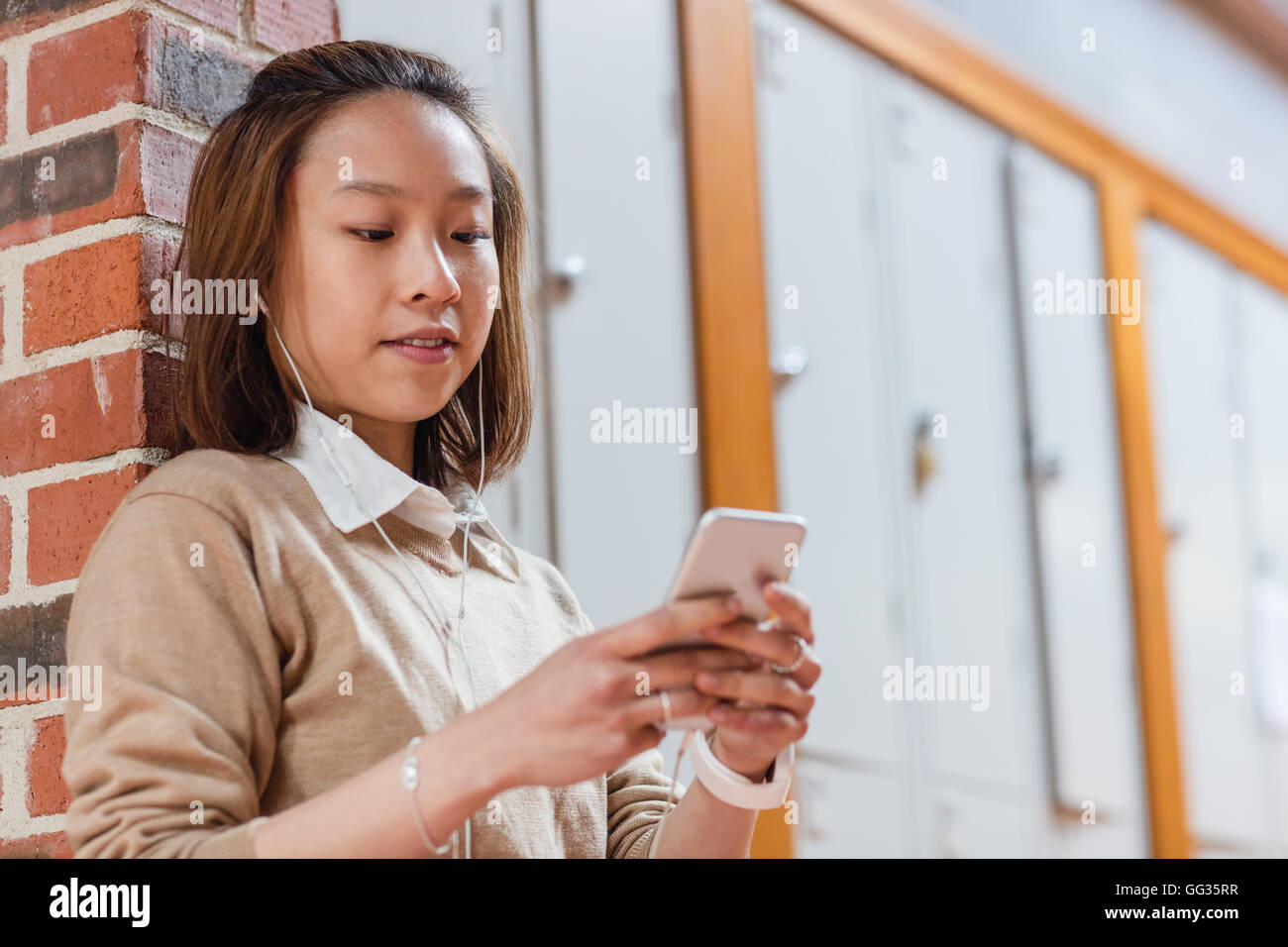 Young woman using mobile phone in corridor Stock Photo - Alamy