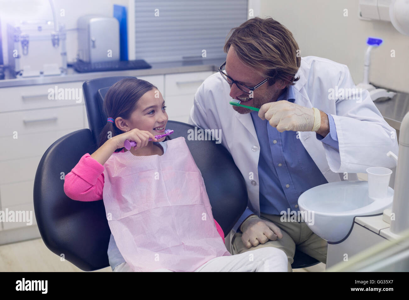 Smiling dentist and patient brushing their teeth Stock Photo - Alamy