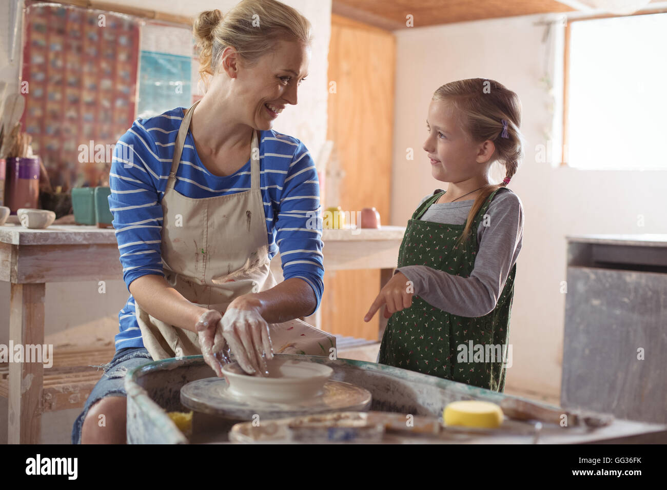 Female potter assisting girl Stock Photo - Alamy