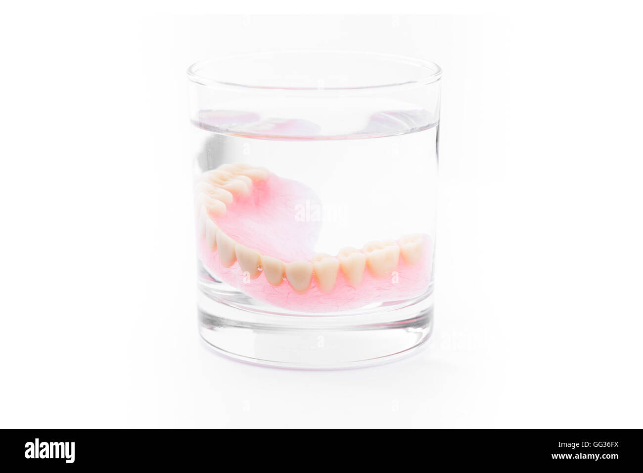 Denture in glass of water on white background Stock Photo - Alamy