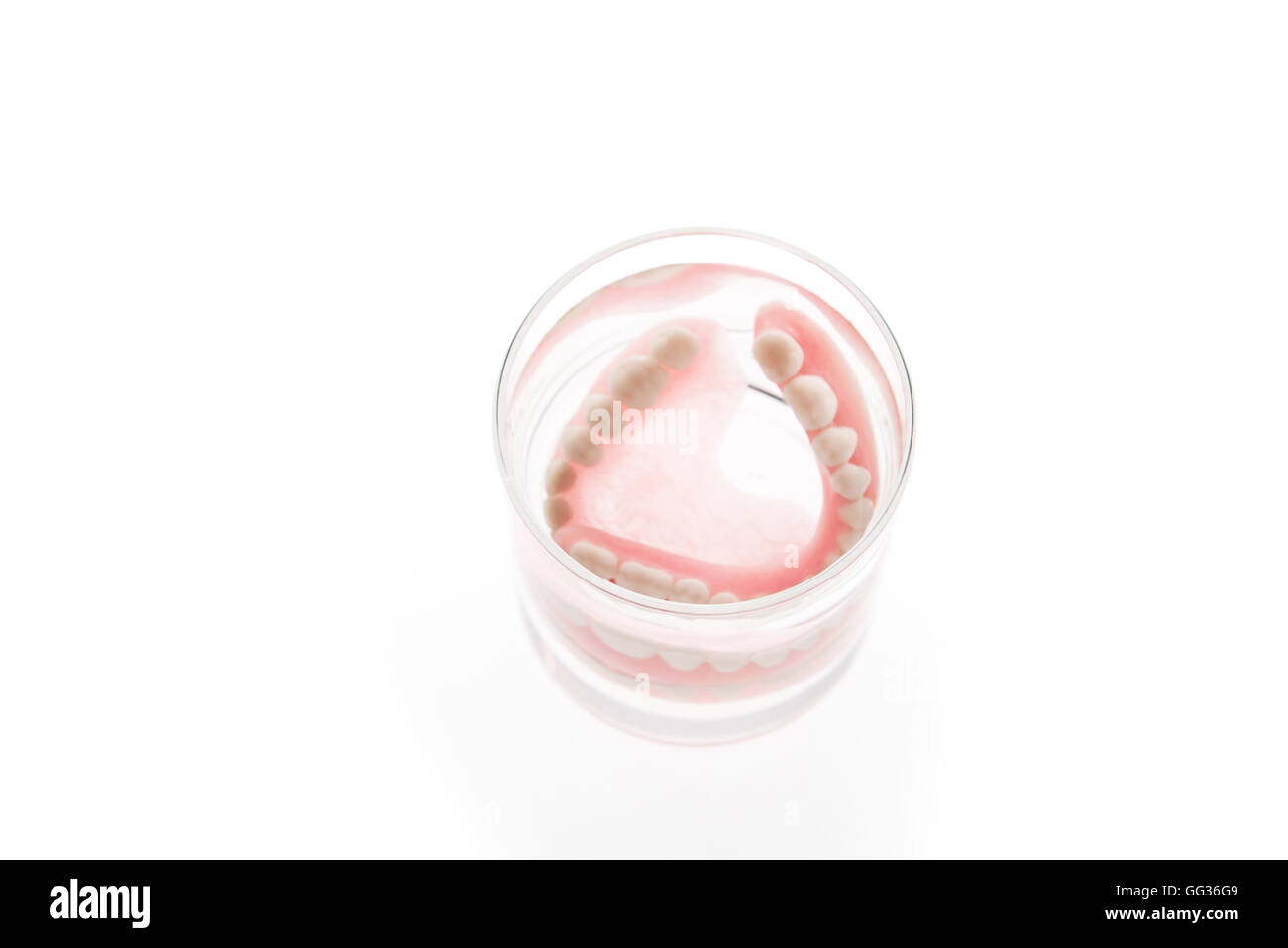 Denture in glass of water on white background Stock Photo - Alamy