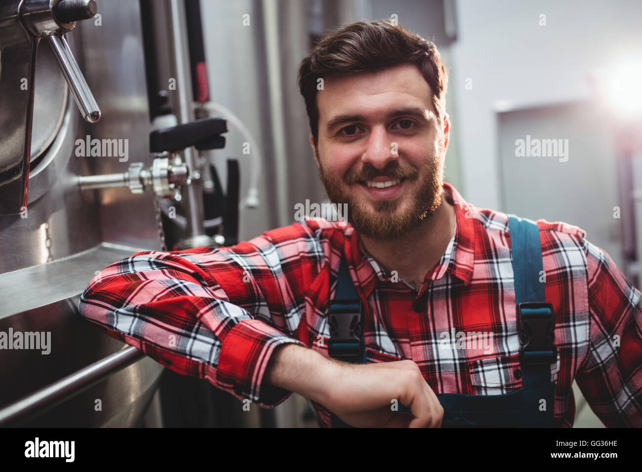 Smiling manufacturer standing by storage tank in brewery Stock Photo ...