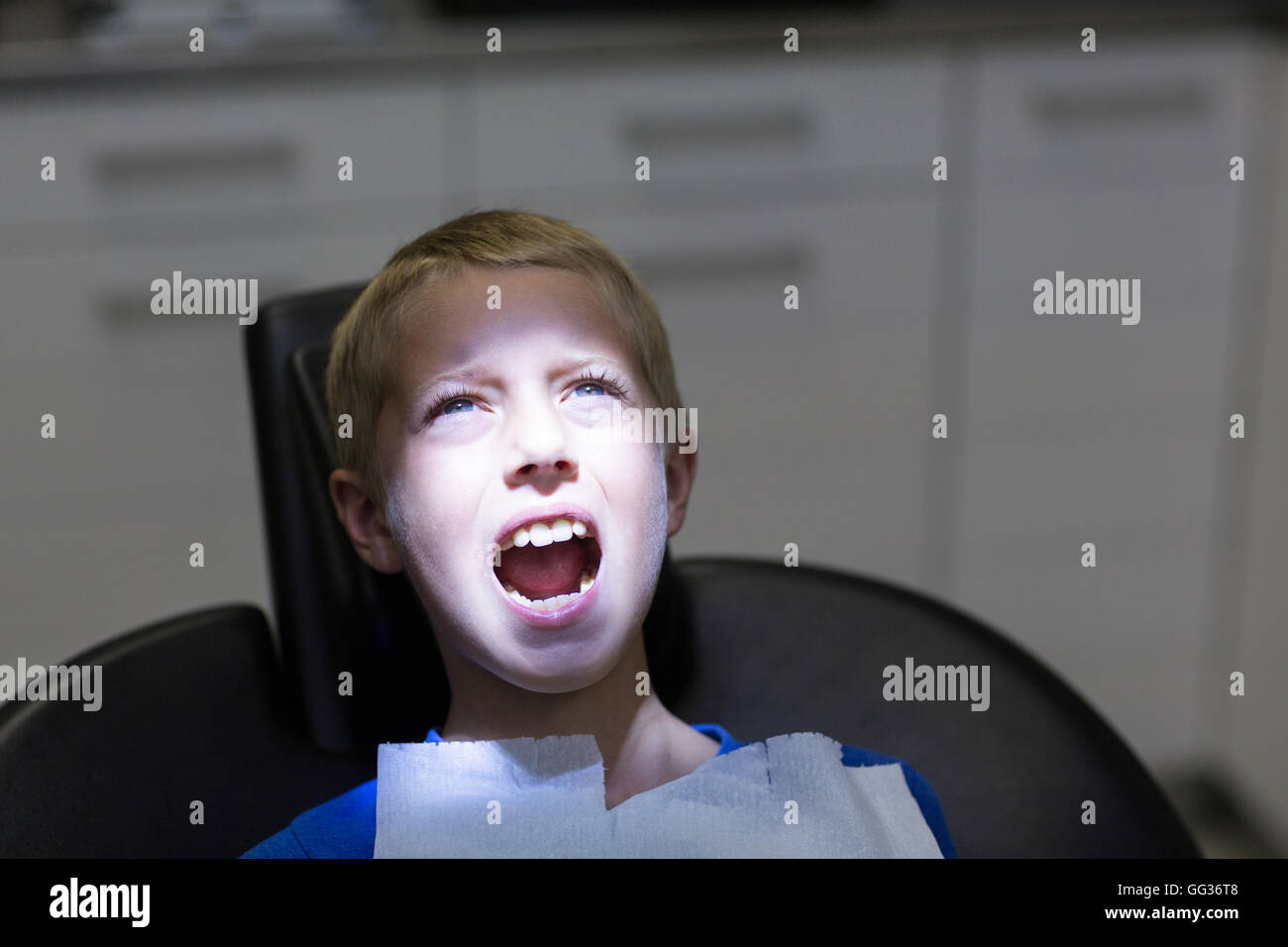Young patient sitting on dentist chair with open mouth Stock Photo - Alamy