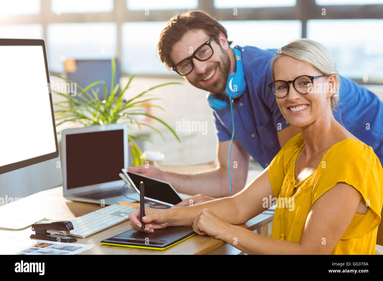 Graphic designers smiling in office Stock Photo - Alamy
