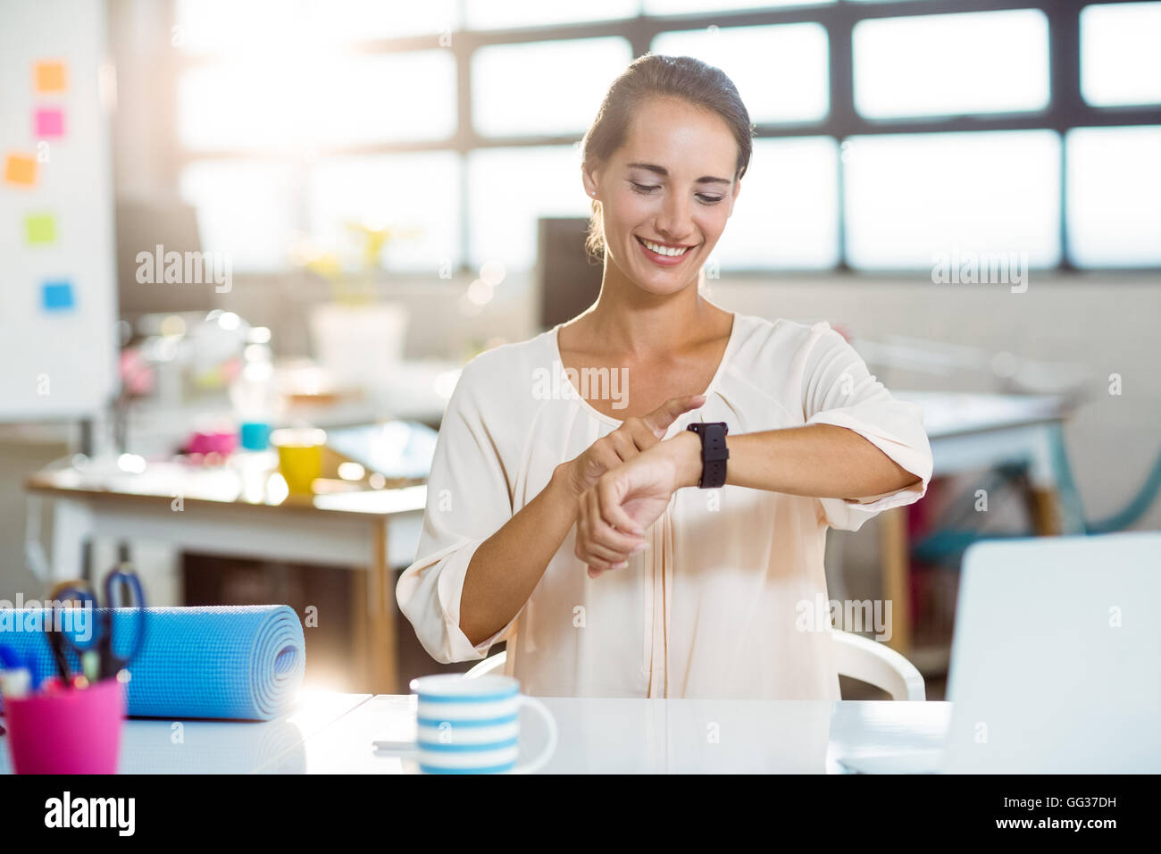 Female business executive adjusting time on her smartwatch Stock Photo ...