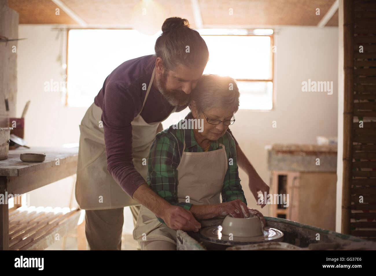 Male potter assisting female potter Stock Photo - Alamy