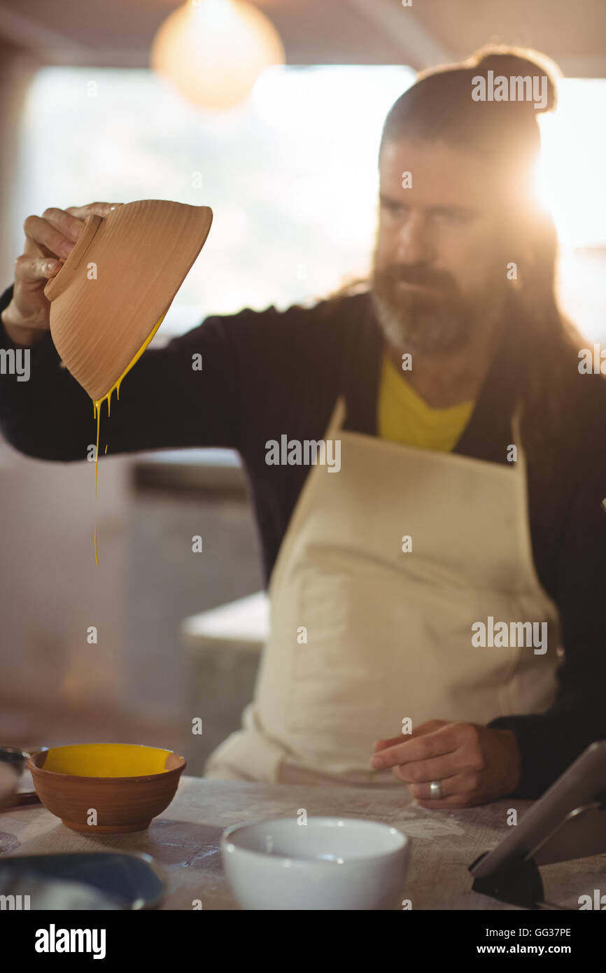 Male potter pouring watercolor in bowl Stock Photo - Alamy