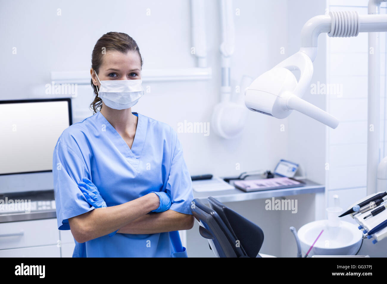 Smiling dental assistant standing with arms crossed Stock Photo - Alamy