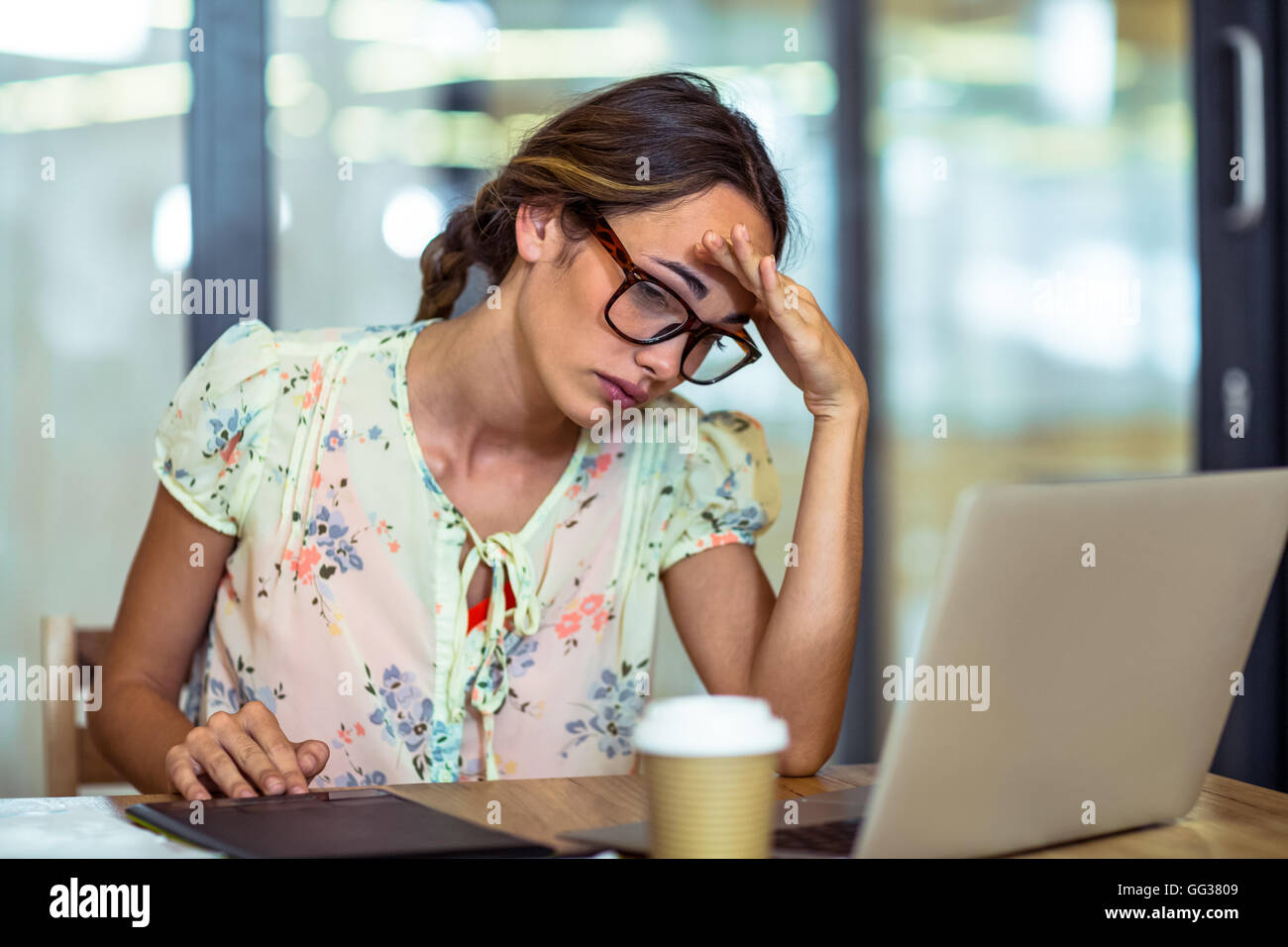 Frustrated female graphic designer looking at laptop Stock Photo - Alamy