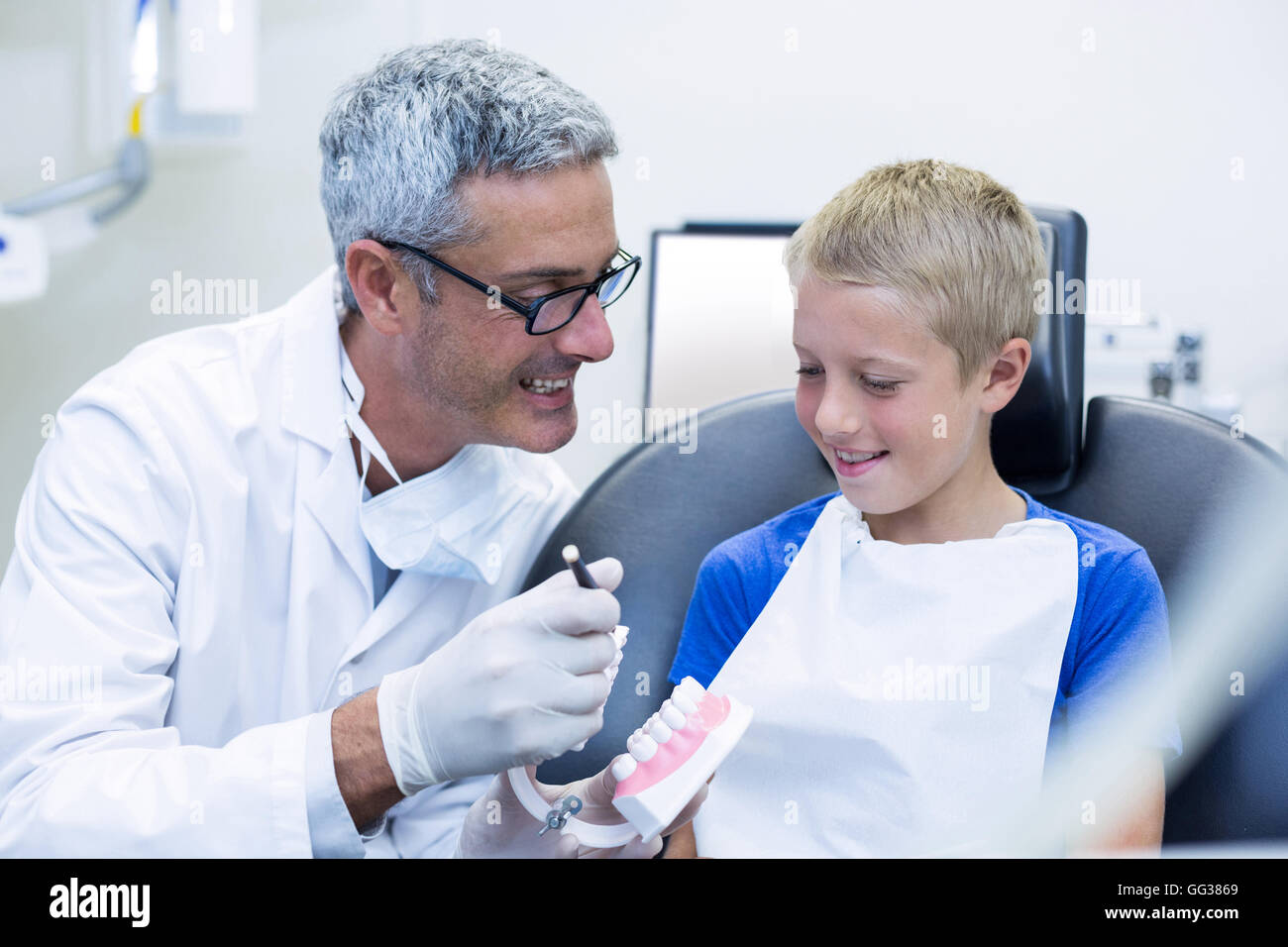 Dentist showing patient model of teeth Stock Photo - Alamy