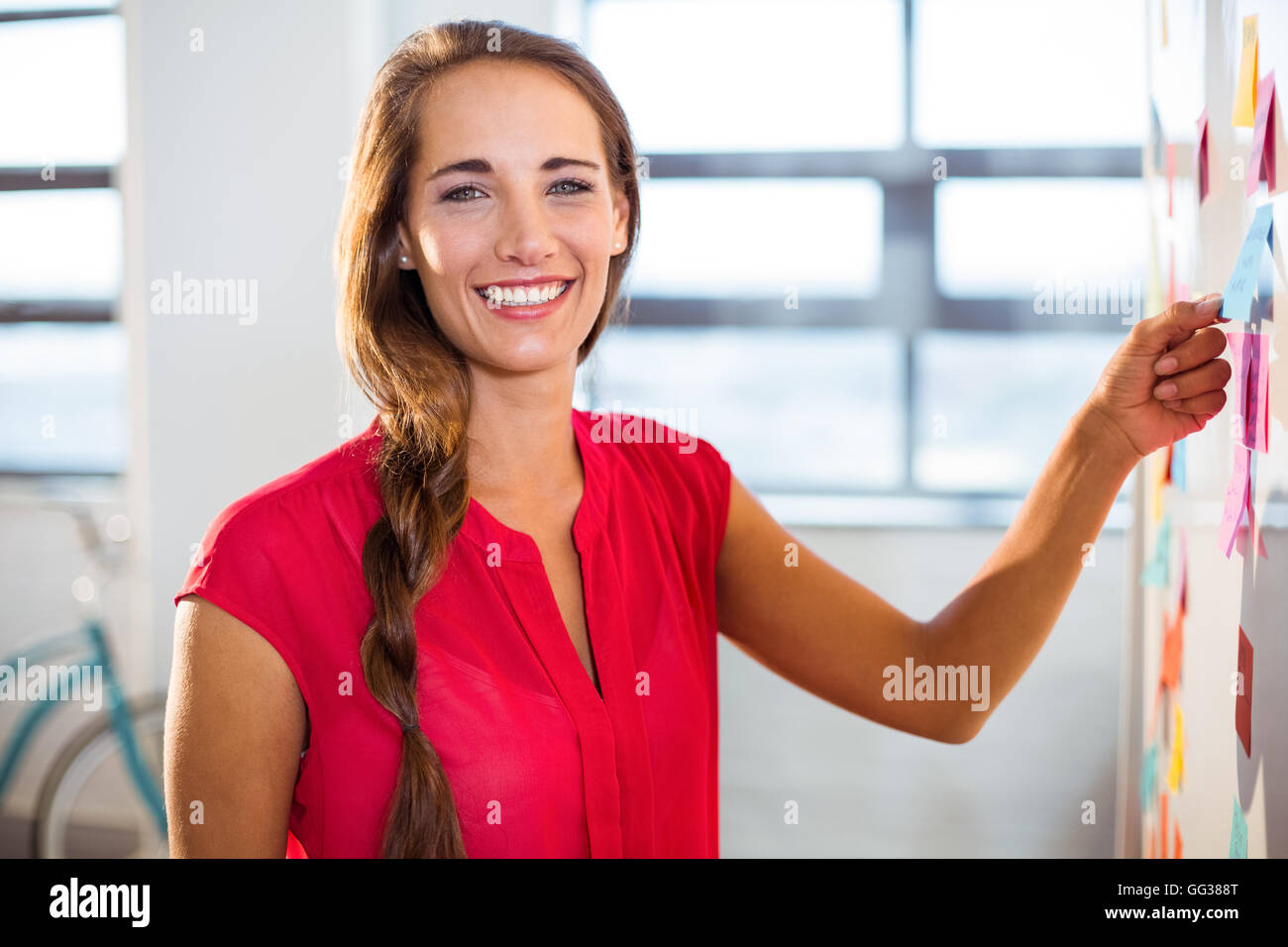 Woman putting sticky notes on whiteboard Stock Photo - Alamy
