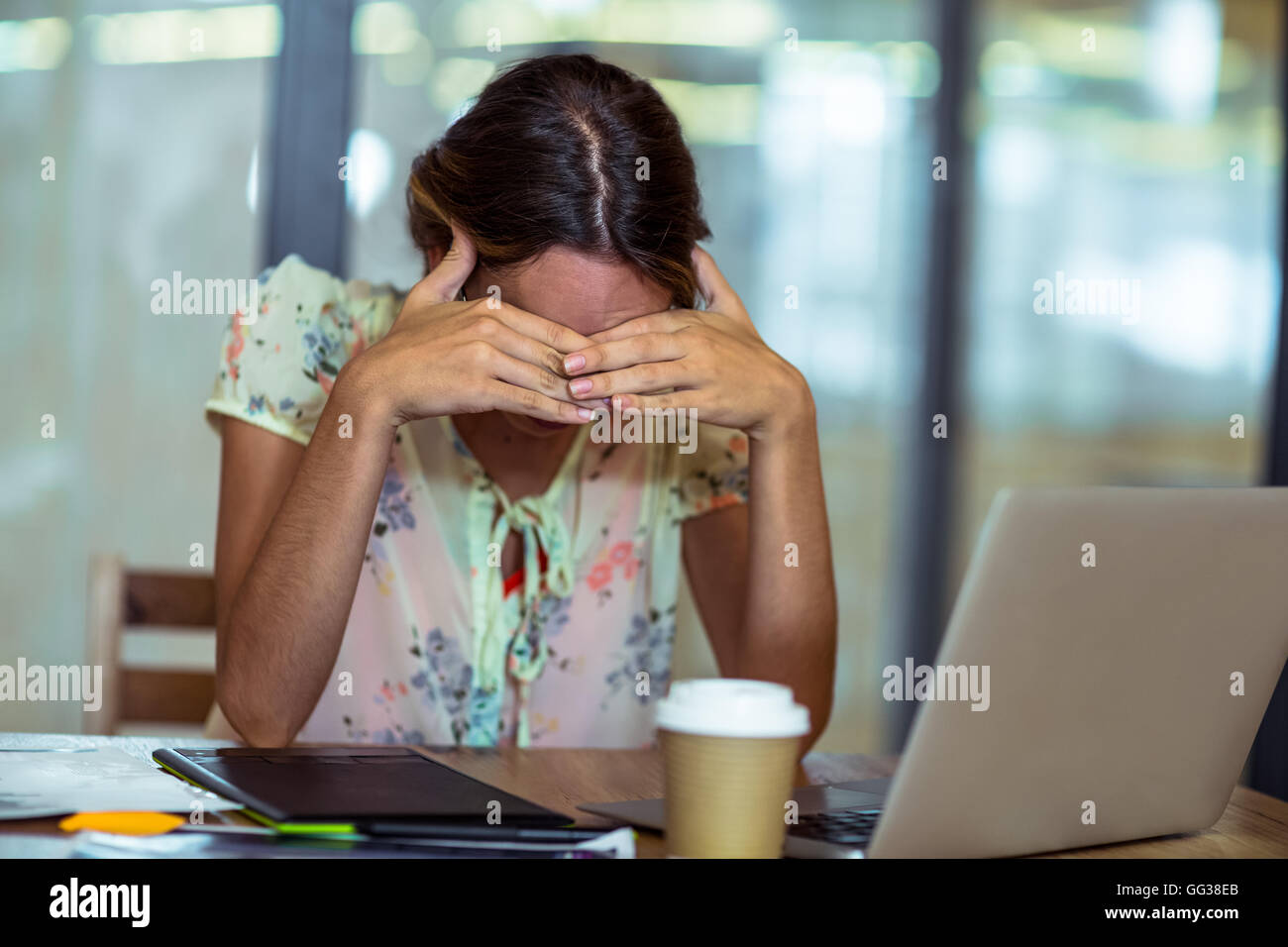 Frustrated female graphic designer sitting with laptop and graphic ...