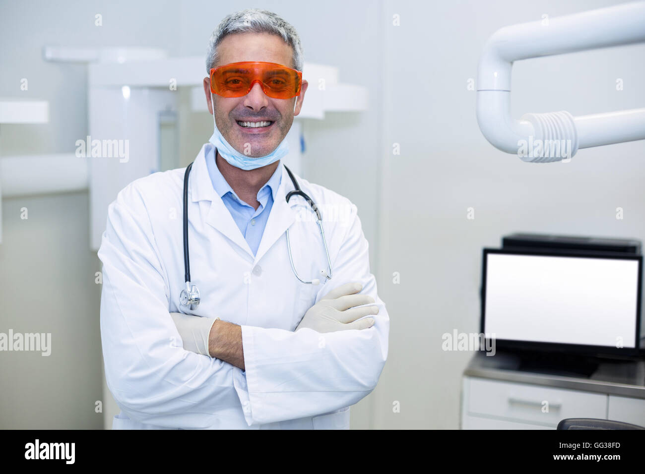 Portrait of smiling dentist standing with arms crossed Stock Photo - Alamy