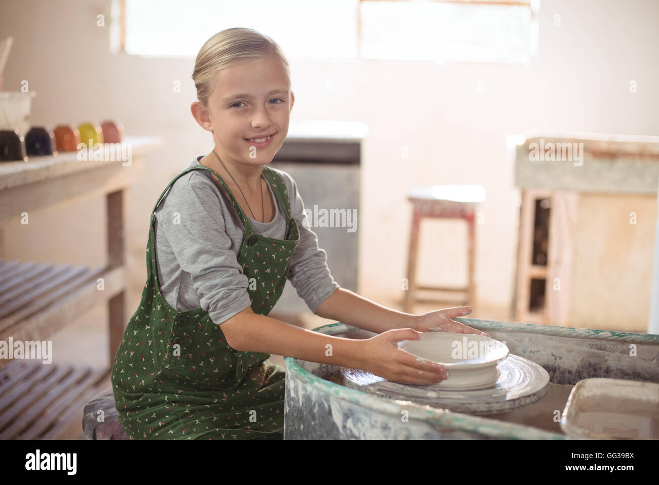 Portrait of happy girl making pot Stock Photo - Alamy