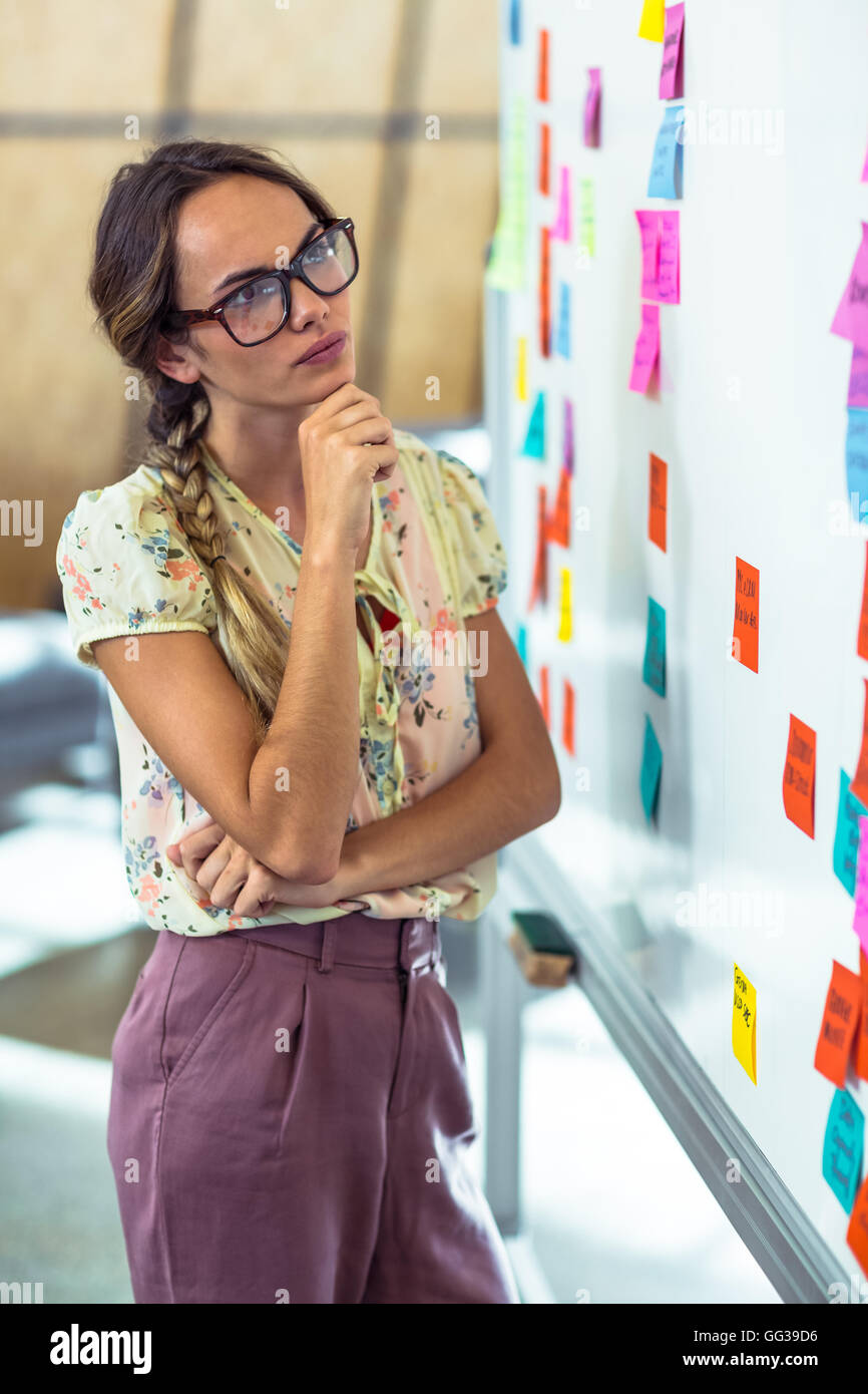 Thoughtful woman looking at sticky notes Stock Photo - Alamy
