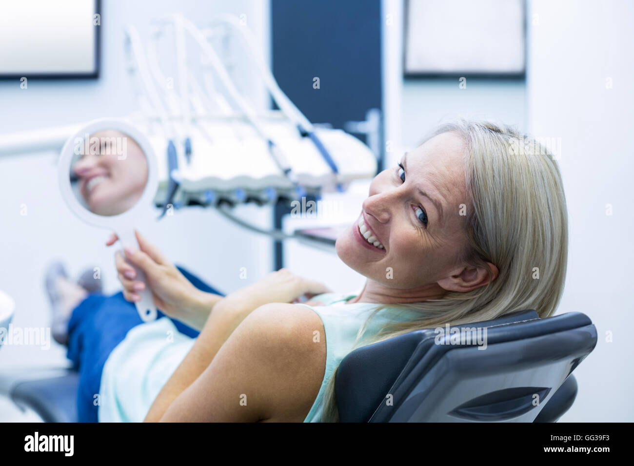 Female patient smiling while holding mirror Stock Photo - Alamy