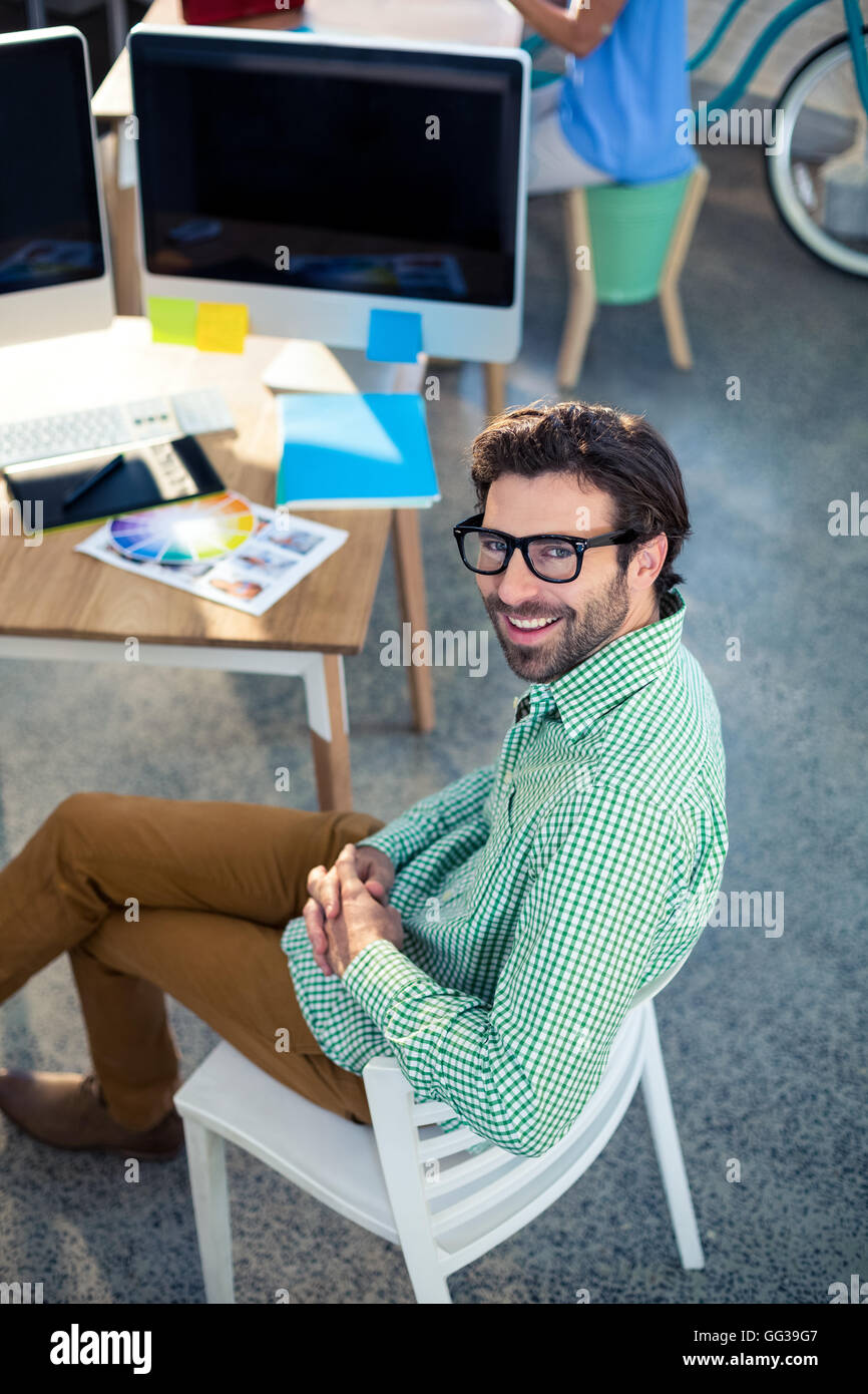 Graphic designer sitting on chair in office Stock Photo - Alamy