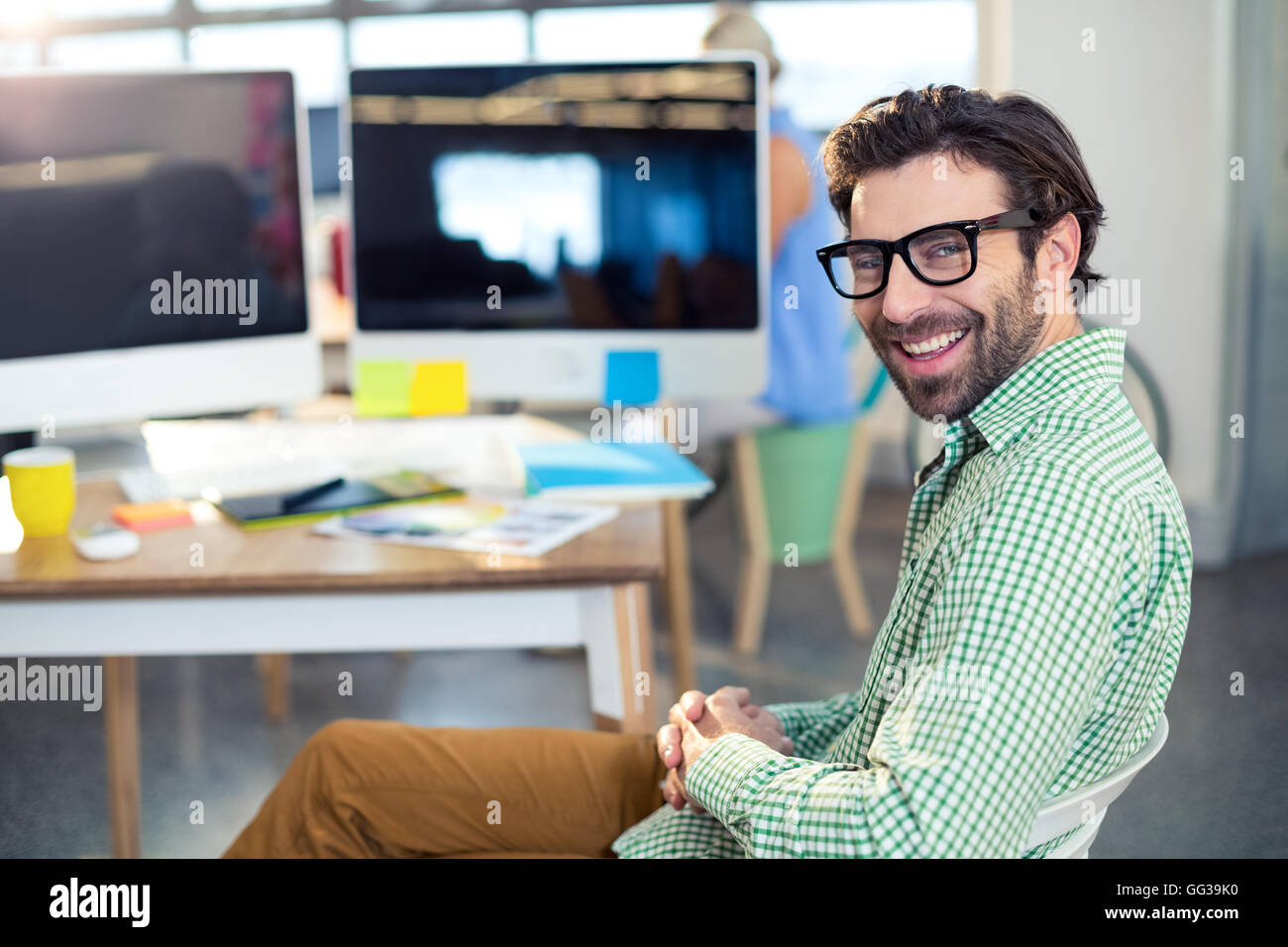 Graphic designer sitting on chair in office Stock Photo - Alamy
