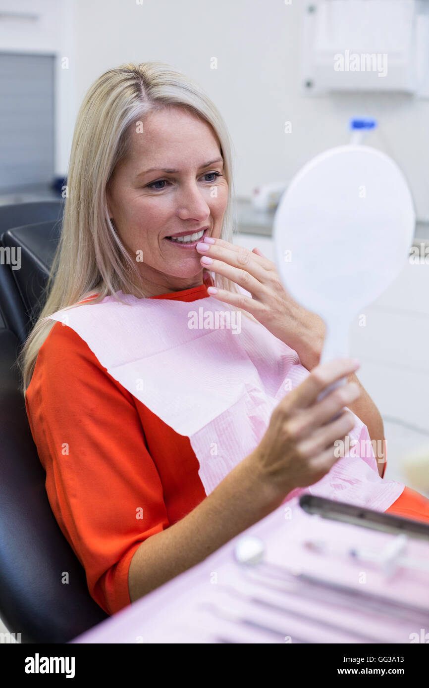 Patient checking her teeth in mirror Stock Photo - Alamy