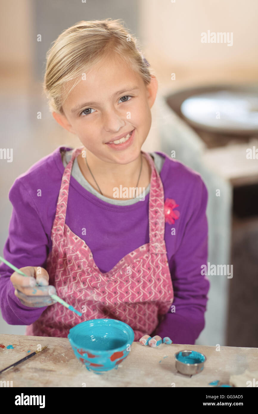 Smiling girl painting on bowl in pottery workshop Stock Photo - Alamy