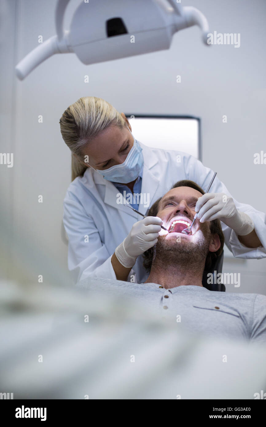 Dentist examining a patient with tools Stock Photo - Alamy Dentist examining a patient with tools Stock Photo - Alamy