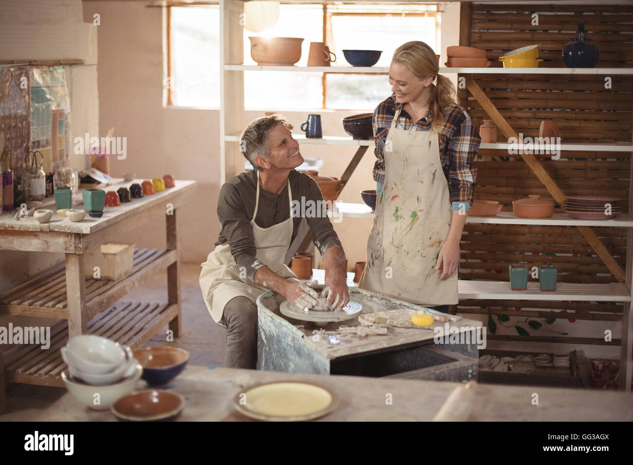 Male potter assisting female potter Stock Photo - Alamy