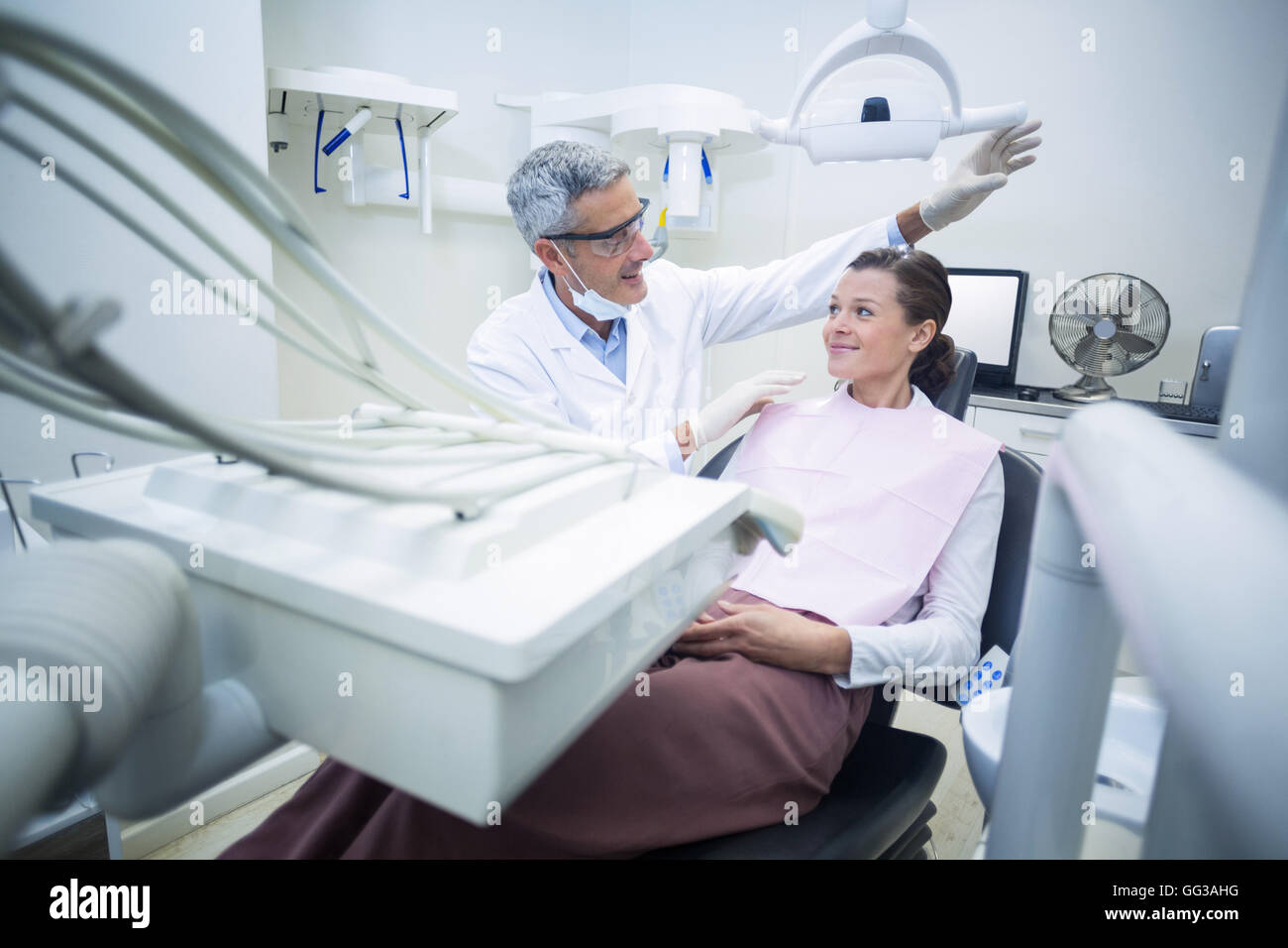 Smiling dentist talking to patient Stock Photo - Alamy