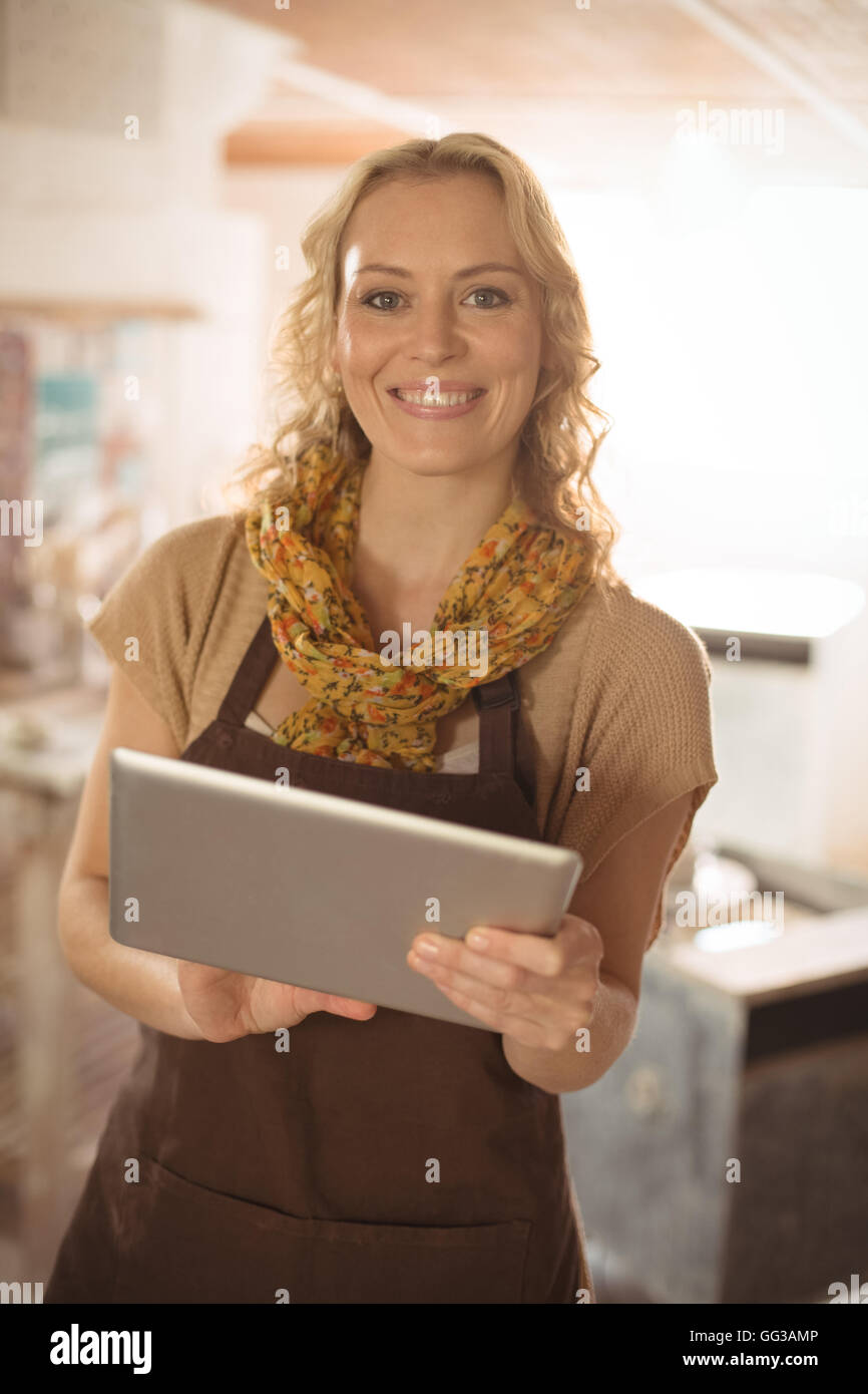 Beautiful female potter using digital tablet Stock Photo - Alamy