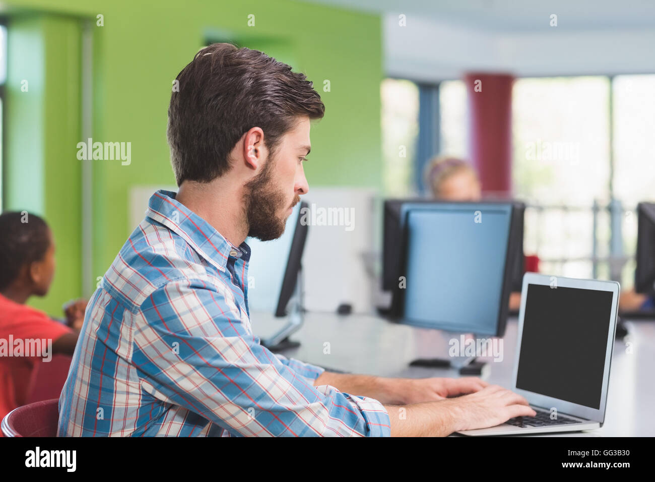 Male teacher using laptop in classroom hi-res stock photography and ...