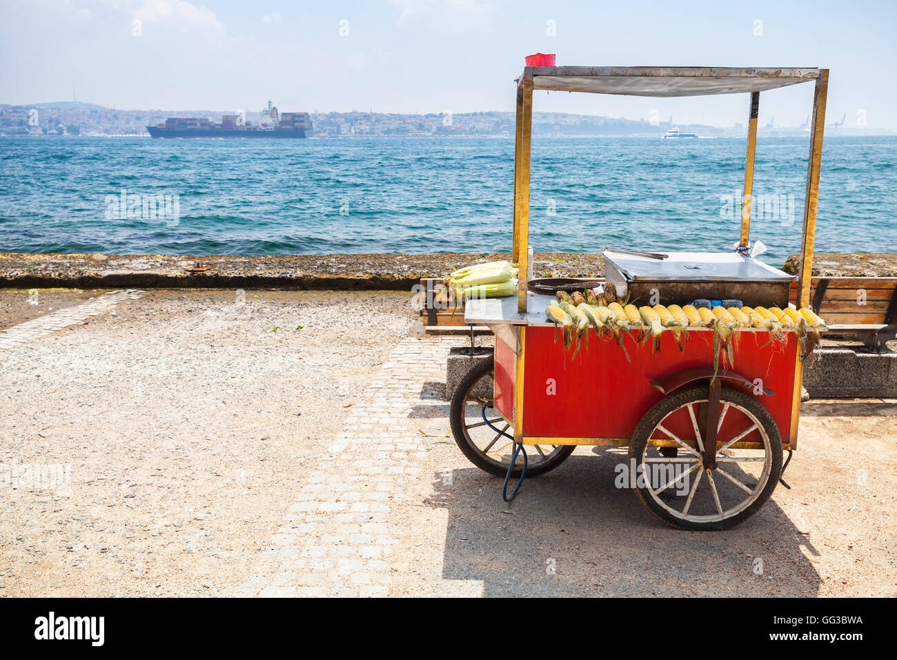 Red selling cart with boiled and roasted corn stands on empty coast of ...
