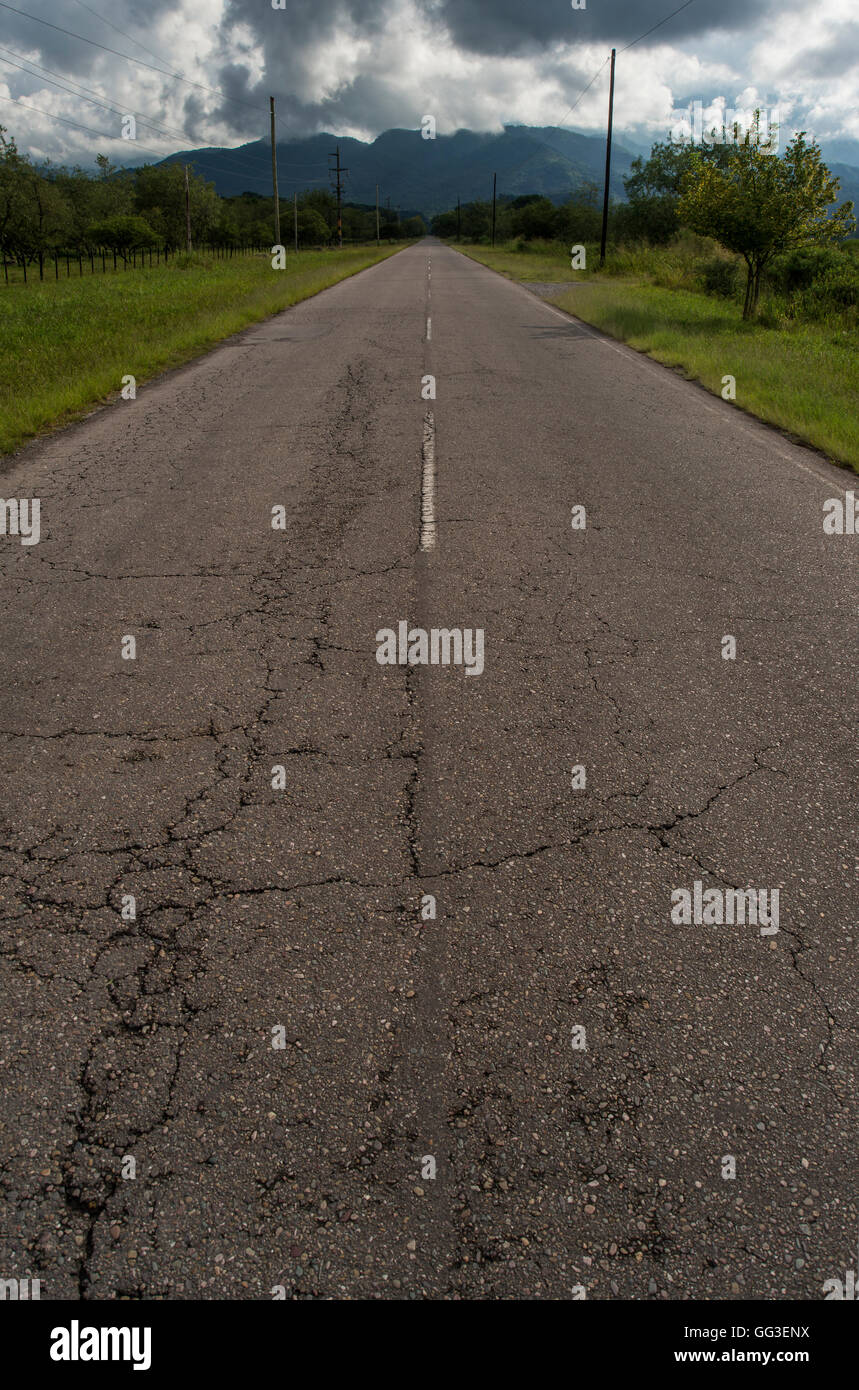 somewhat deteriorated old road through the countryside, mountains and ...