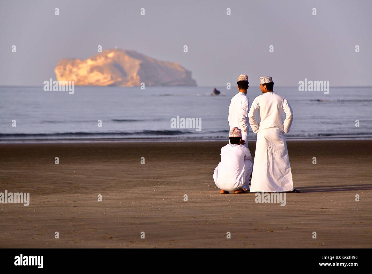 Three Omani men traditionally dressed on the main beach in Central ...