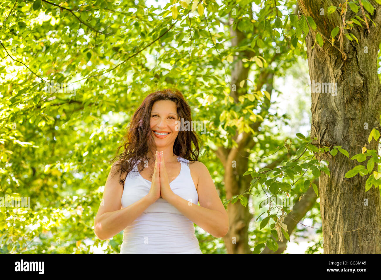 attractive woman praying with clasped hands for Blessings Stock Photo ...