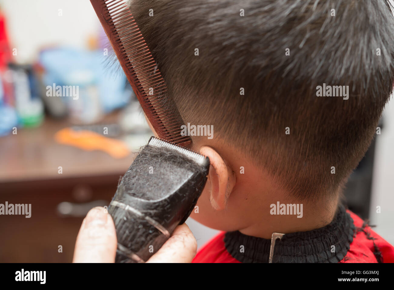 professional hairdresser doing hair cutting for a boy Stock Photo - Alamy
