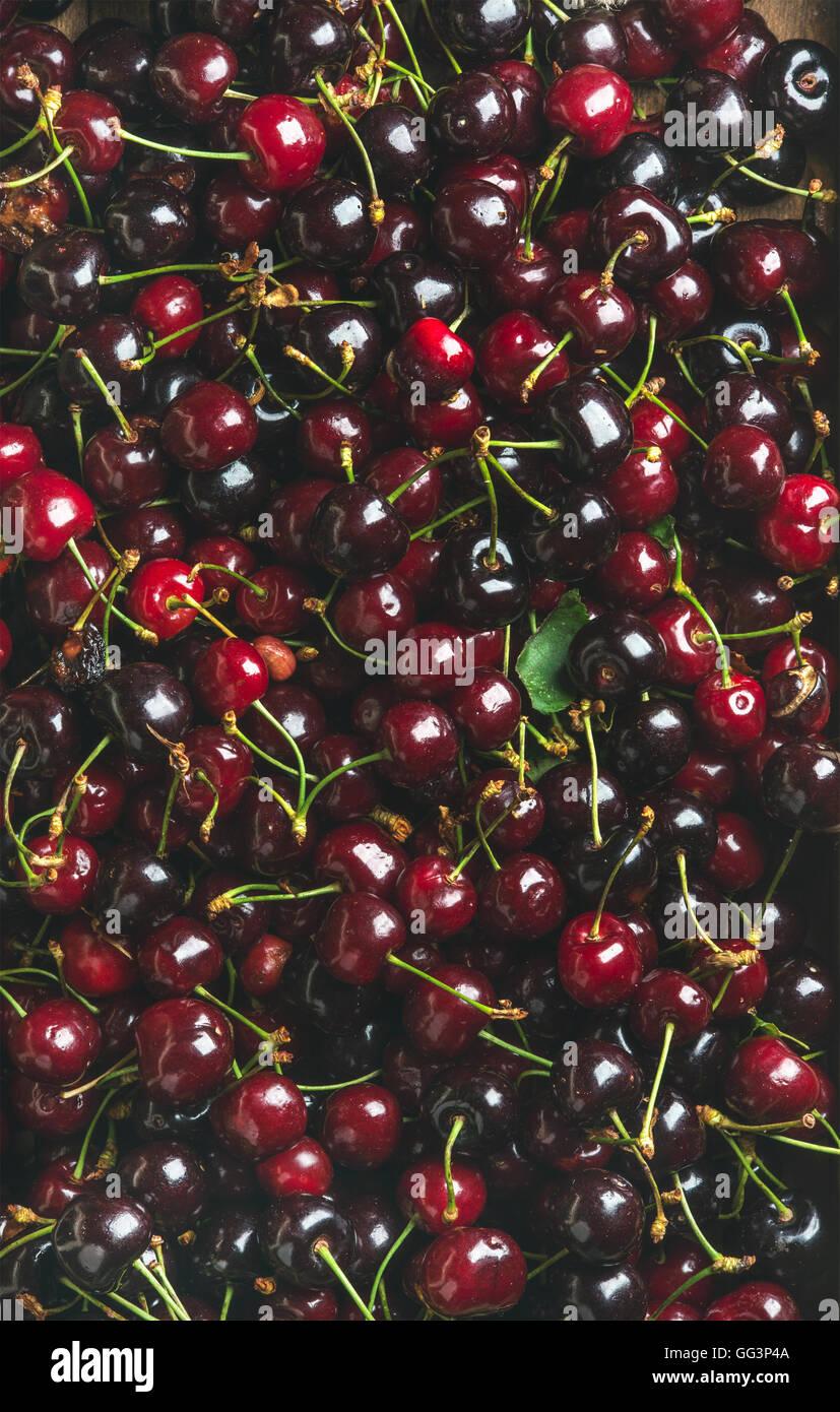 Background of dark red sweet cherries over wooden backdrop Stock Photo ...