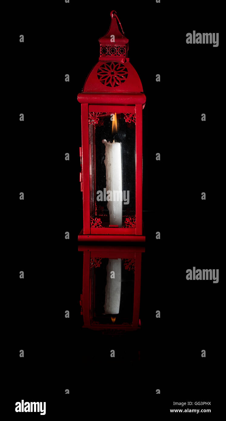 red candle lamp with white candle on black background on his own ...