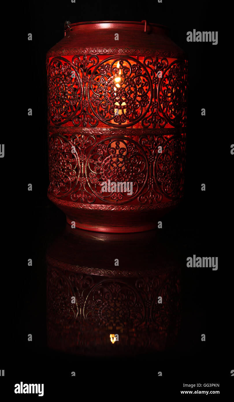 red candle lamp with white candle on black background on his own ...