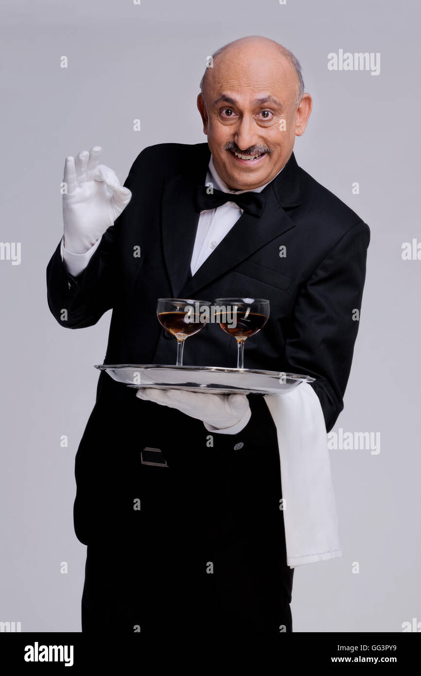 Butler holding some drinks Stock Photo - Alamy