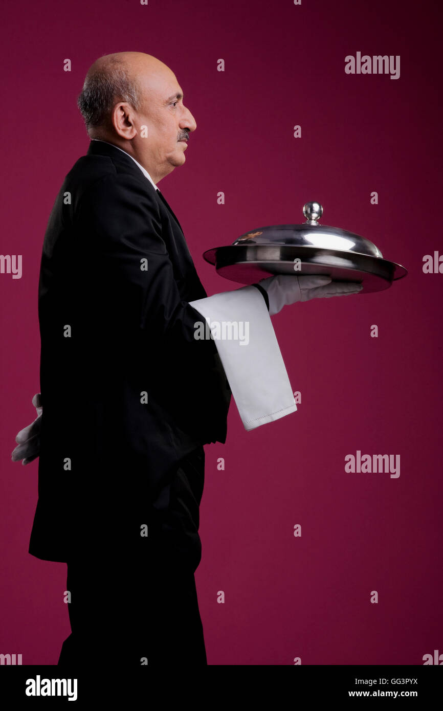 Butler with serving platter Stock Photo - Alamy