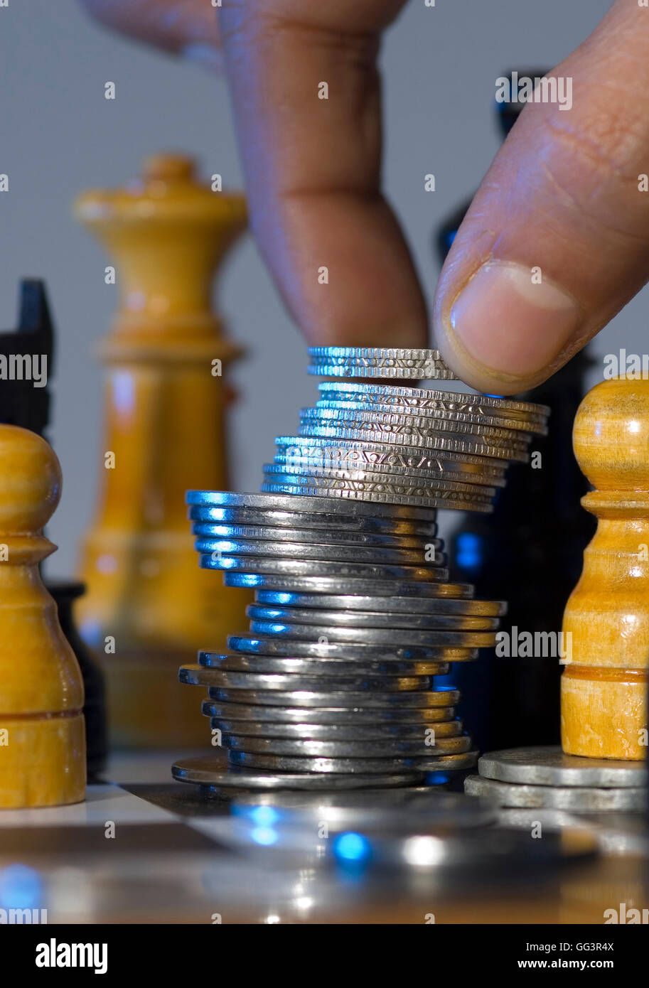 Coins stacked on a chess board Stock Photo - Alamy