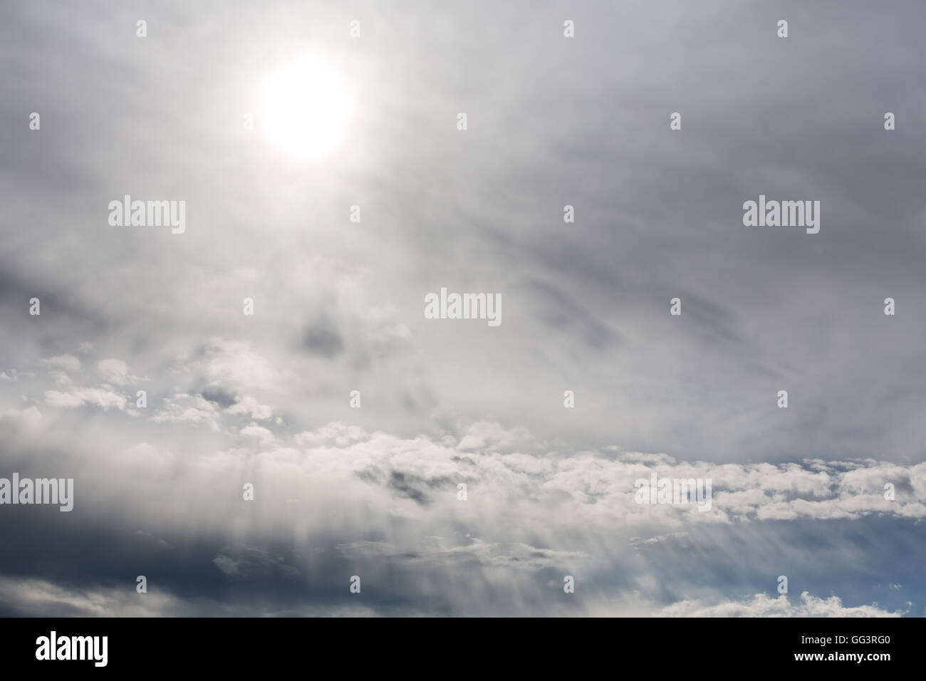 grey sky with dark clouds and light shining through them in rainy day ...