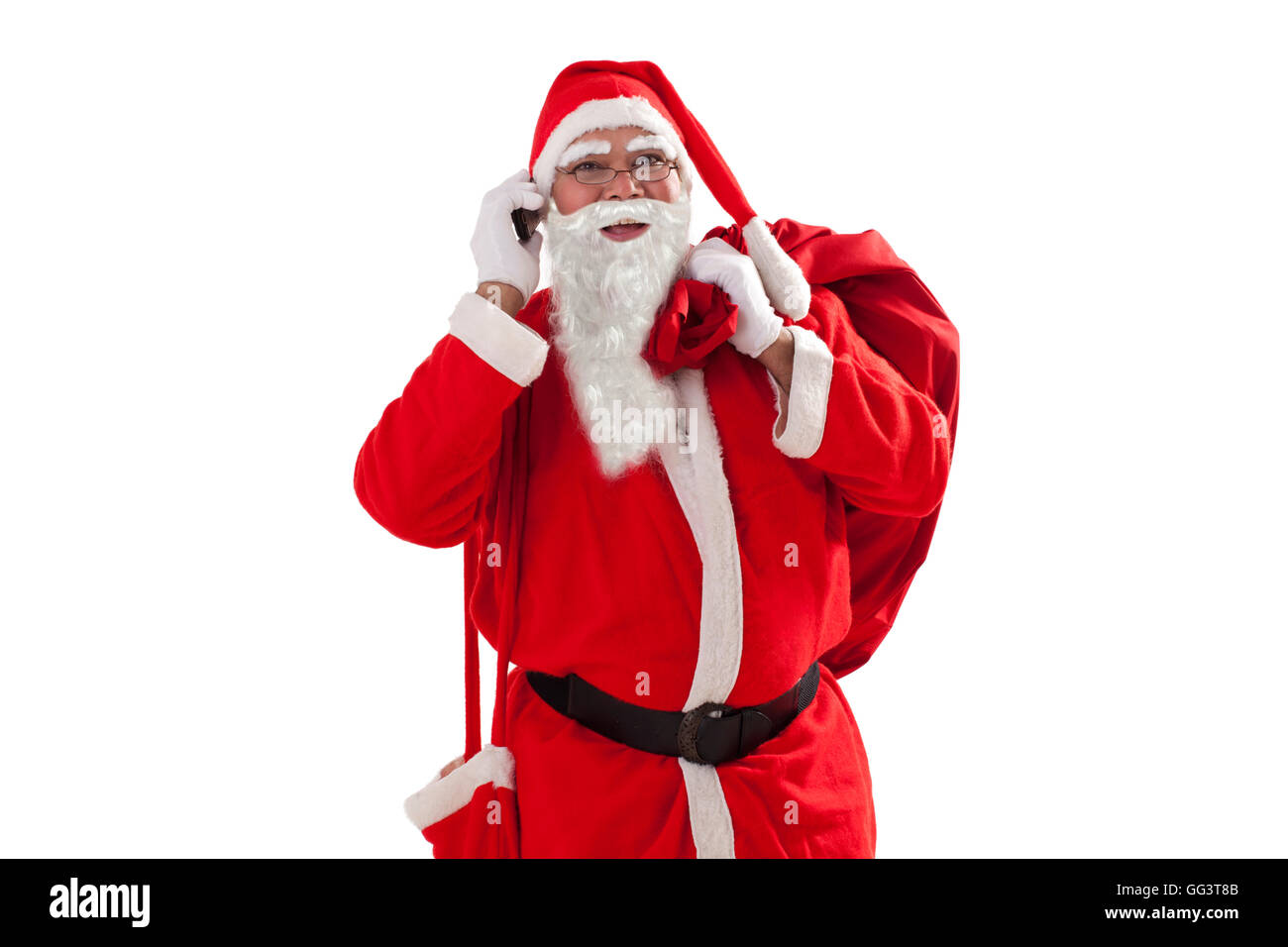 Portrait of Santa Claus talking on mobile phone while carrying sack ...