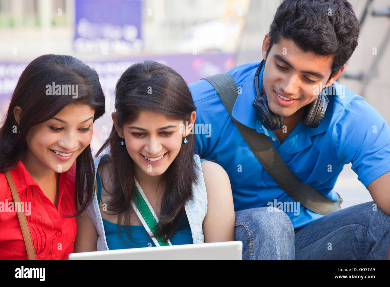 Group of happy friends using laptop Stock Photo - Alamy