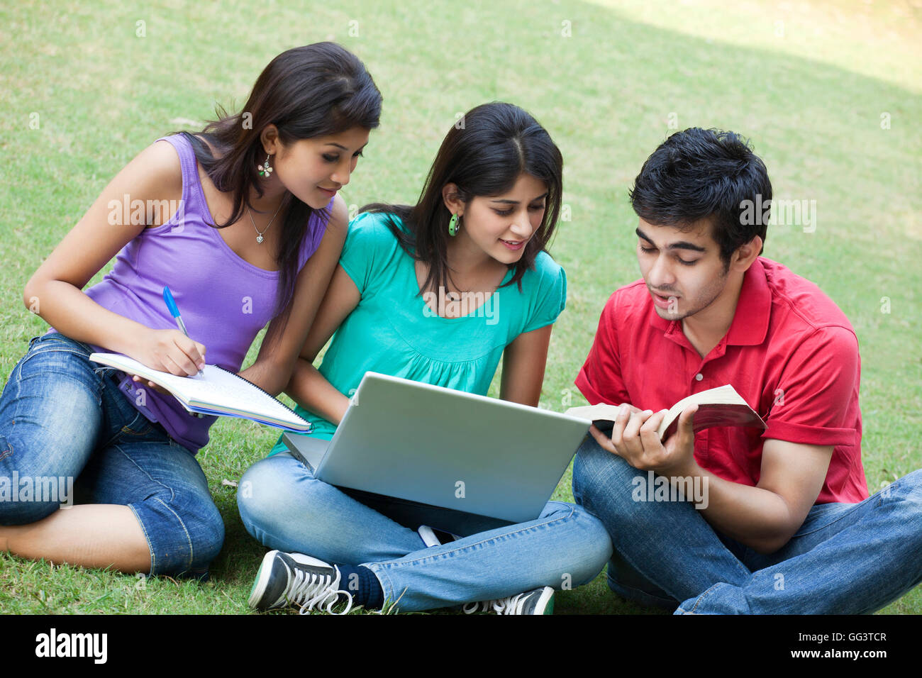 Group of students studying while sitting in lawn Stock Photo - Alamy