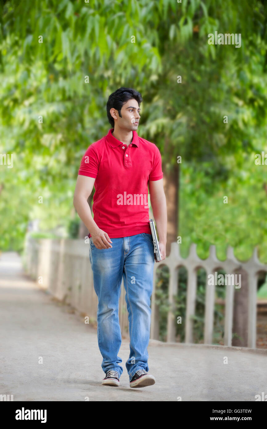 Young man walking in park Stock Photo - Alamy