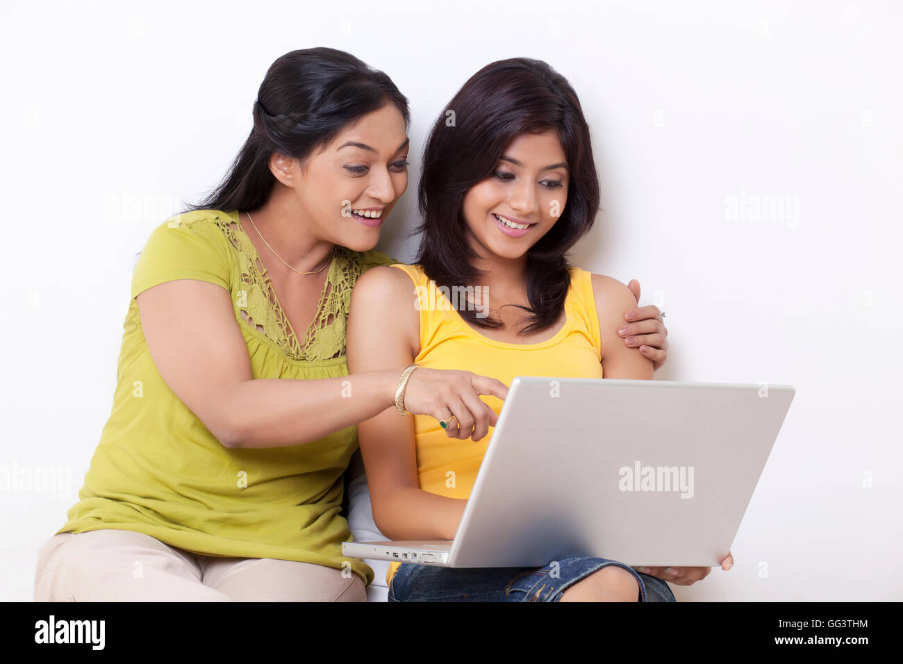 Mother and daughter using computer together over white background Stock ...