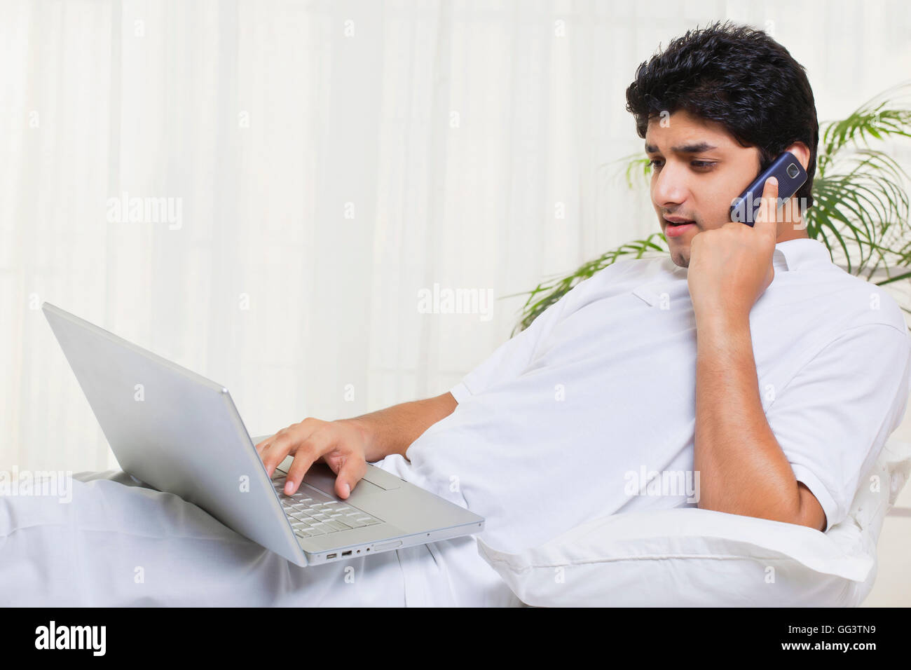 Young man having conversation while using laptop at home Stock Photo ...